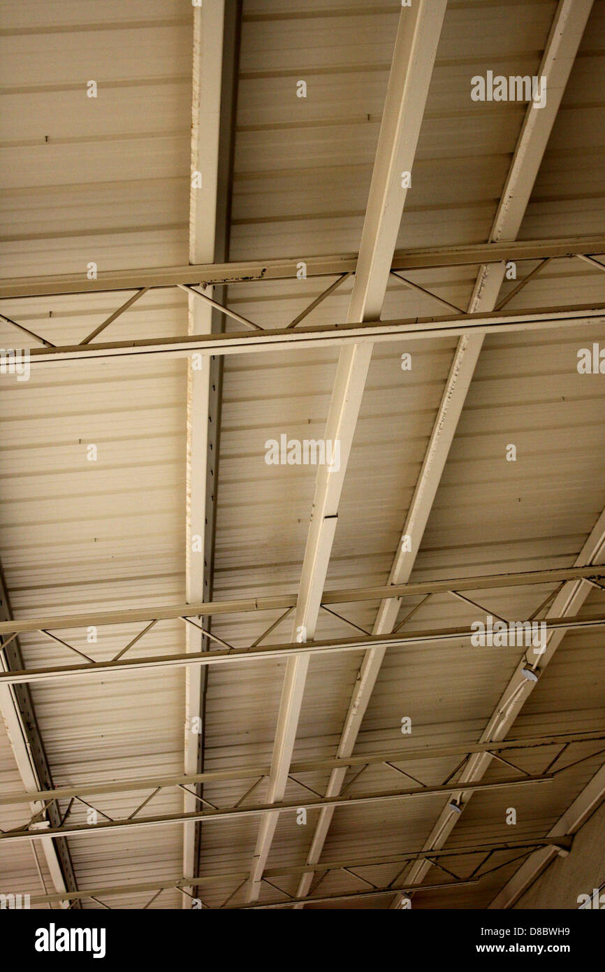 A close-up of the underside of a metal roof, showing the support beams ...
