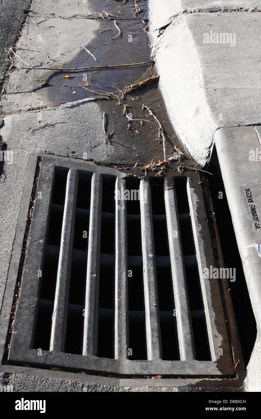 Water flows into a storm drain, illustrating the urban drainage system ...