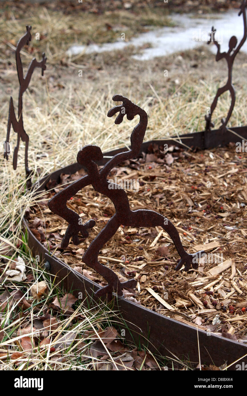 A welded metal sculpture depicting a tree ring with dancing men around ...