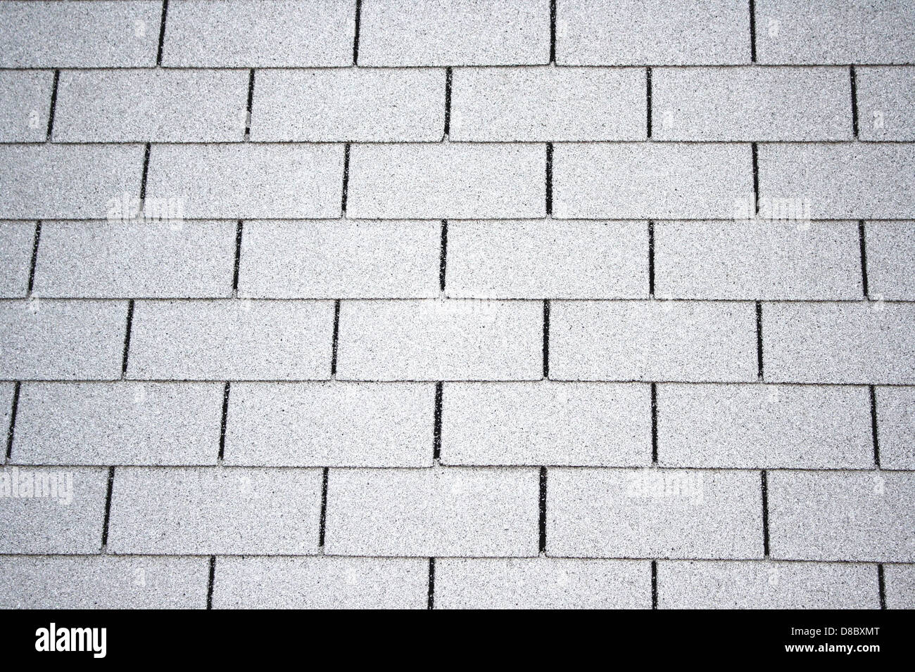 A close-up of white asphalt roof shingles, displaying their smooth ...