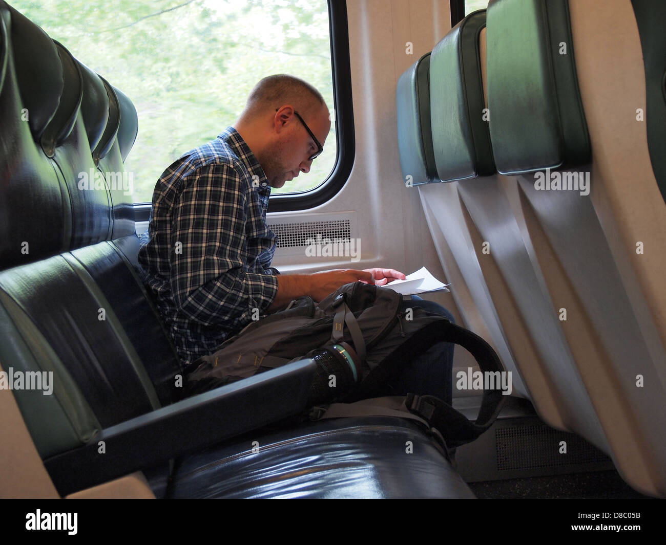 Man reading work papers on a Metro-North Railroad commuter train in New ...