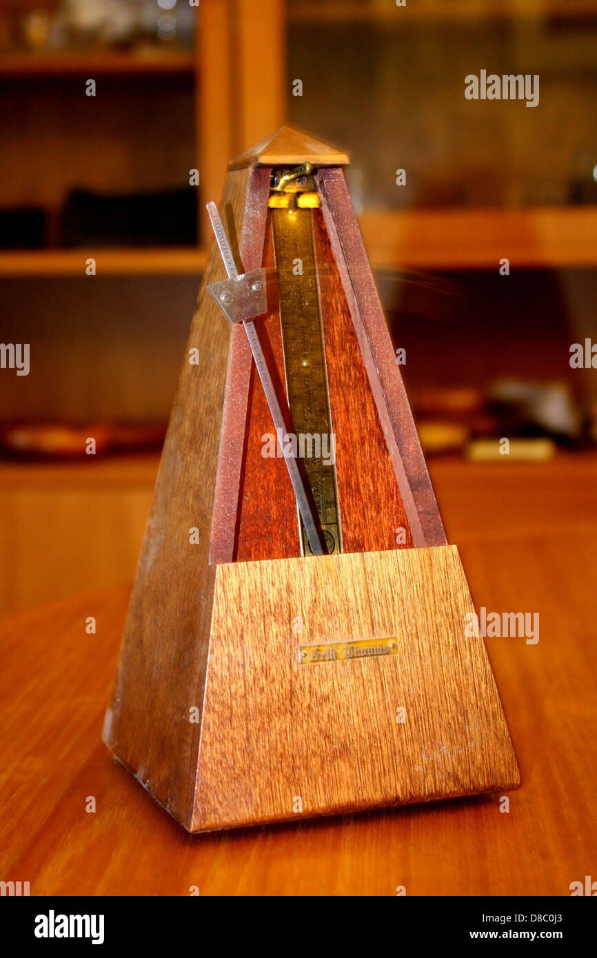 A wooden metronome with a swinging pendulum, indicating a steady tempo ...