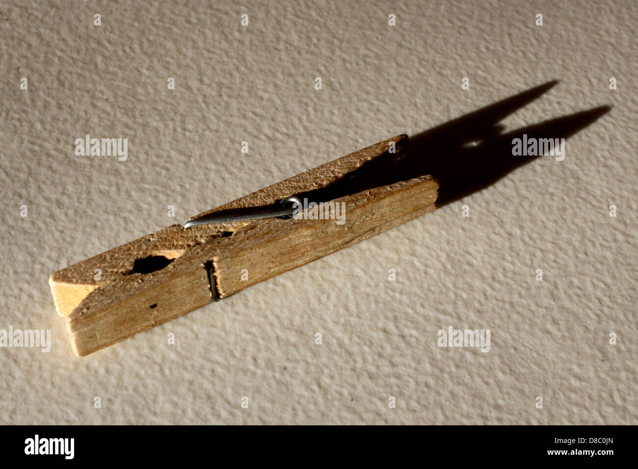 A simple wooden clothespin, a common household item used for hanging ...
