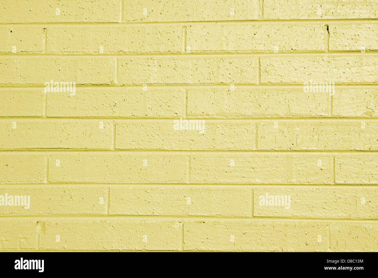 This image shows a textured yellow-painted brick wall. The wall’s ...