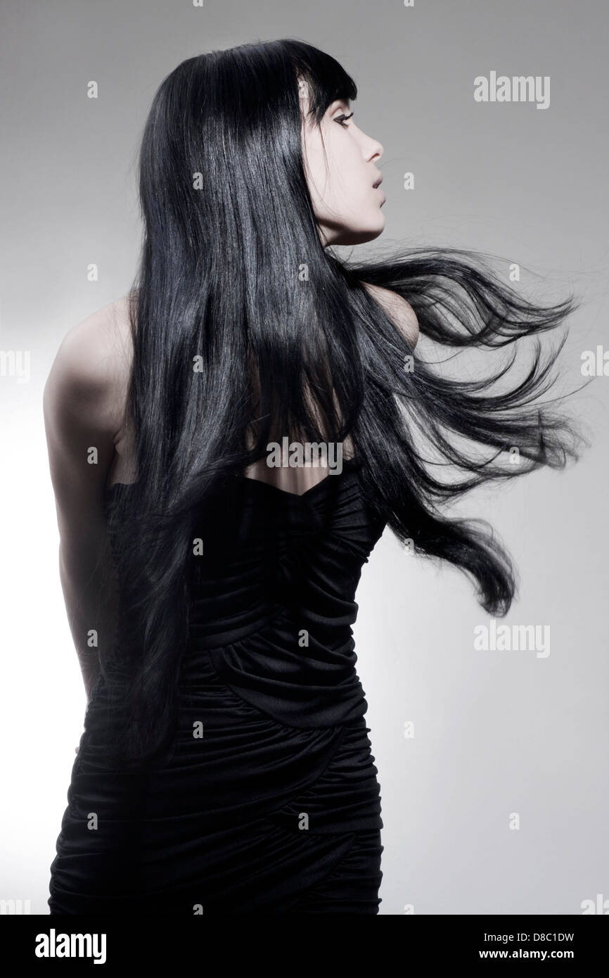Attractive dark-haired young woman wearing black dress Stock Photo - Alamy