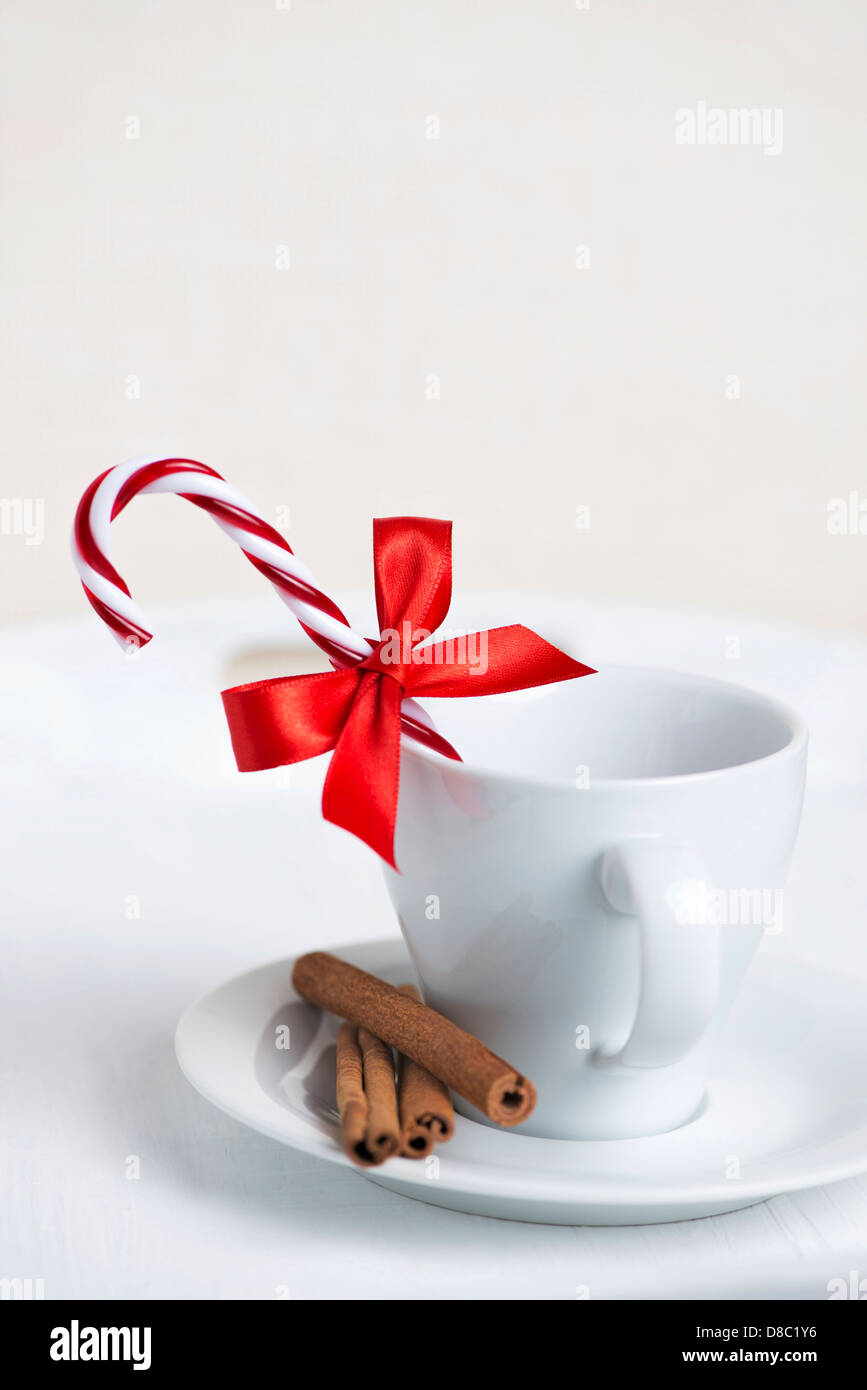 Cup decorated with candy cane, red ribbon and cinnamon sticks Stock ...