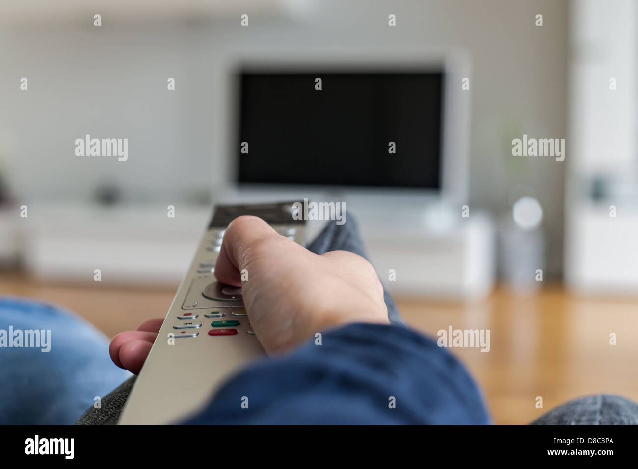 hand pushing button on remote control for home cinema Stock Photo - Alamy