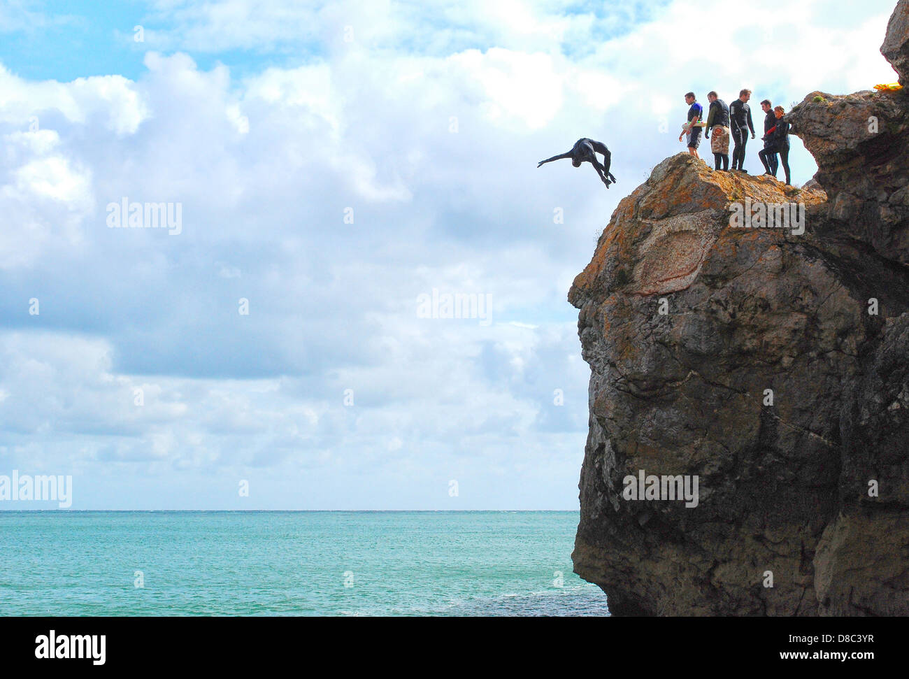 Man back flips off of rocky cliff in to sea Stock Photo - Alamy