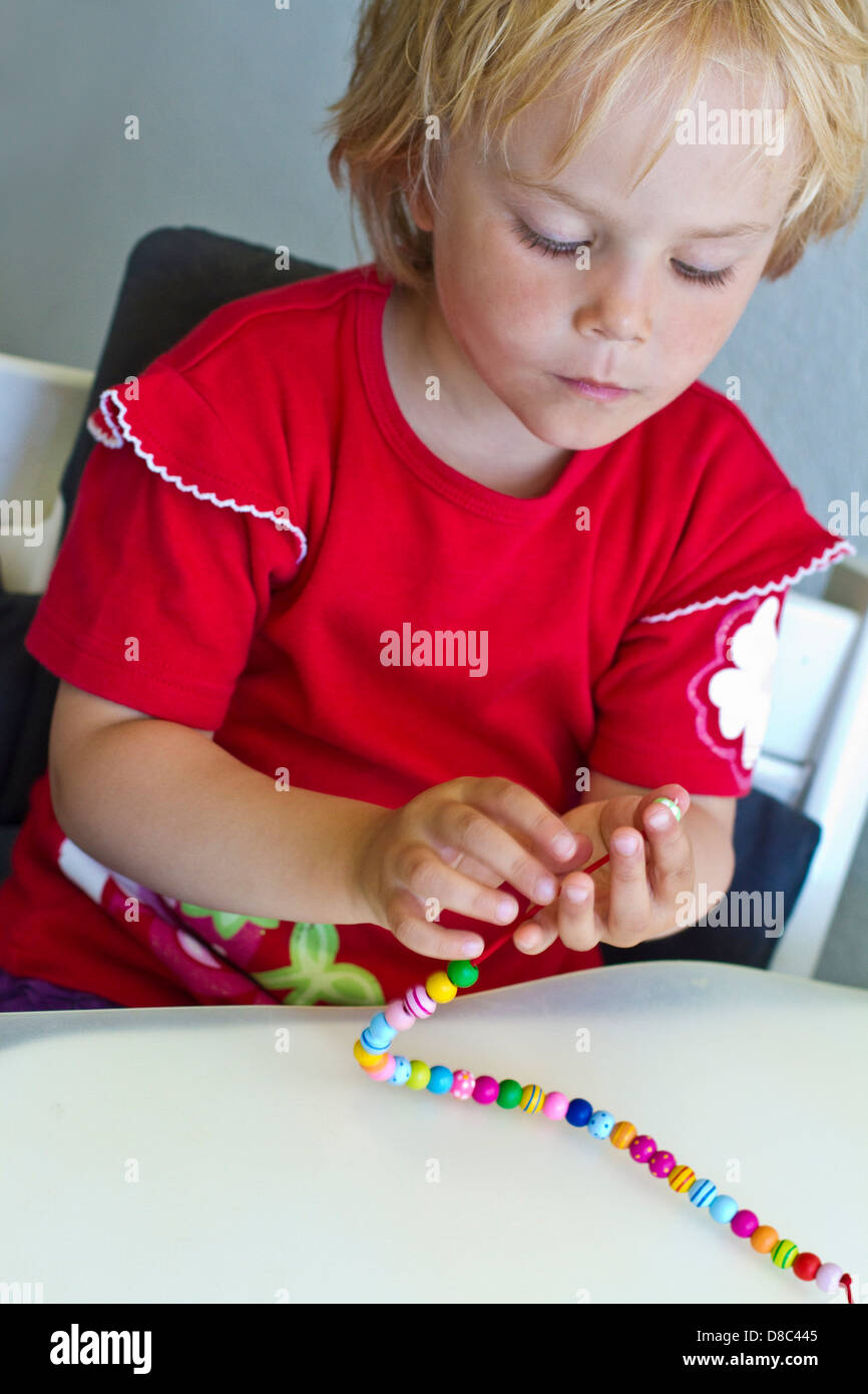 Girl tinkering a pearl necklace Stock Photo - Alamy