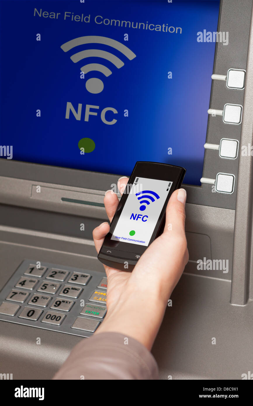 withdrawing money from atm with a mobile phone a NFC terminal Stock ...