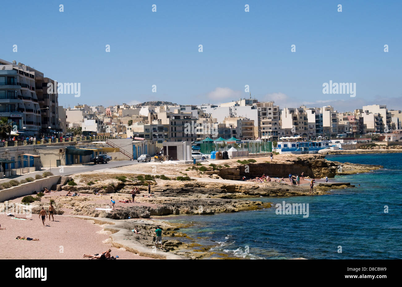 Tourists enjoy the man made beach in Bugibba Malta. Hotels and ...