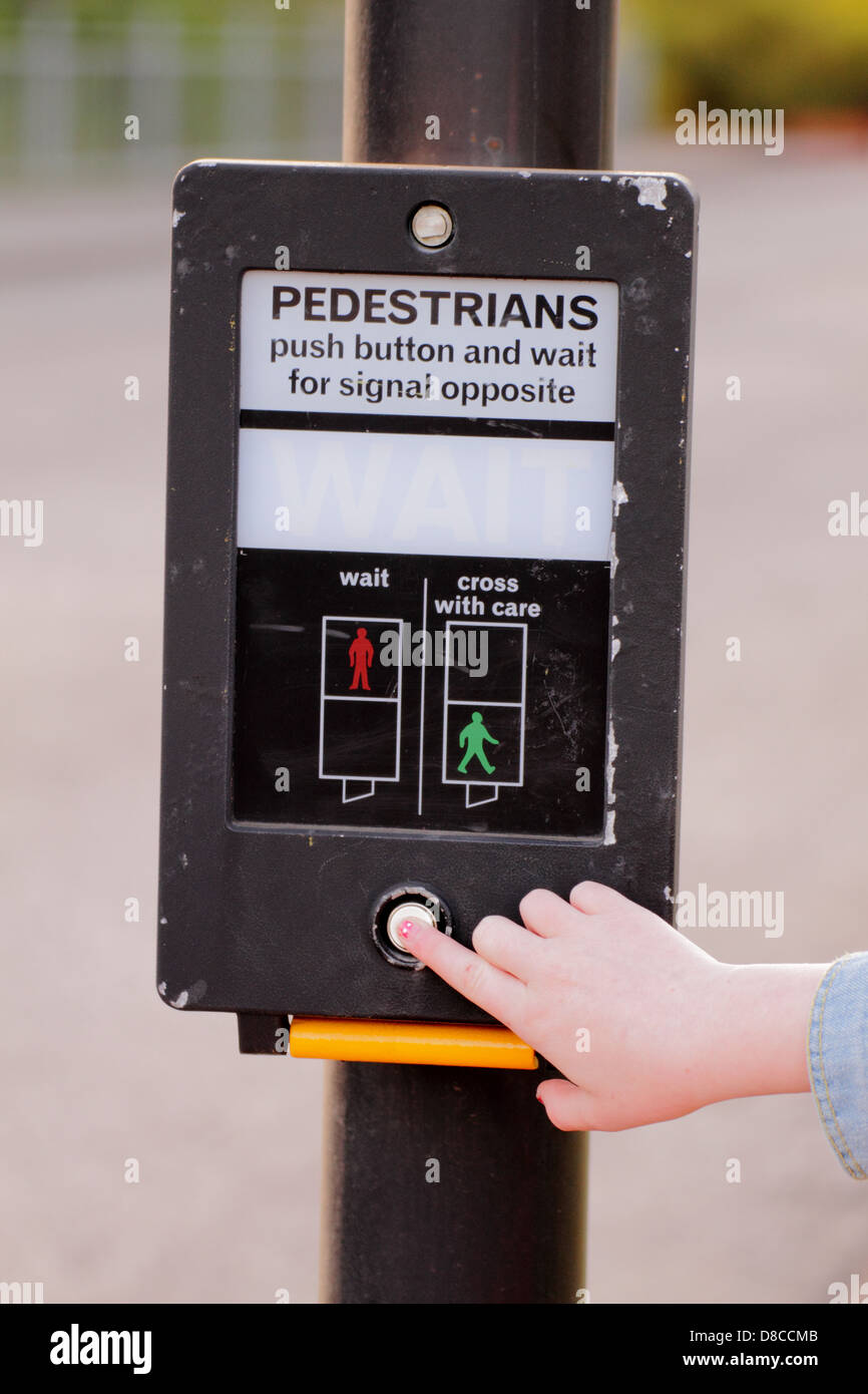 young girl teen hand pressing the signal button on a pedestrian ...