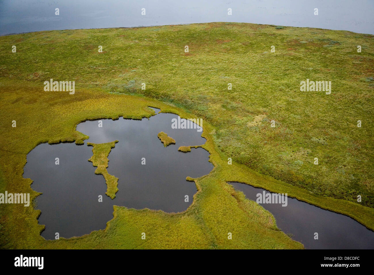 An aerial image showing landmass surrounded by bodies of water. This ...