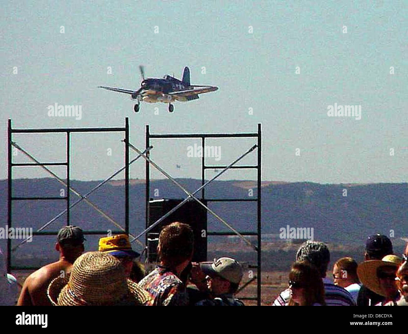 An aircraft flying low in the sky, close to the ground. The plane's ...