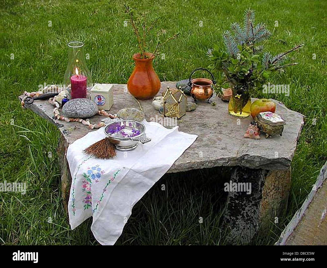 A serene altar scene featuring vases, rocks, and candles arranged in a ...