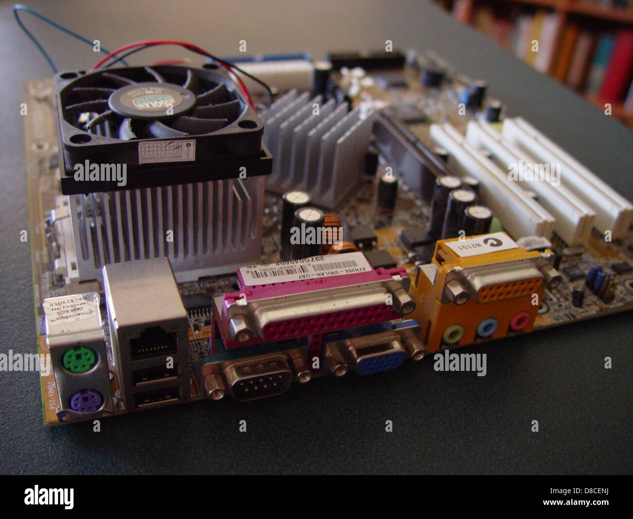 A close-up of an ATX computer motherboard with its CPU and cooling fan ...