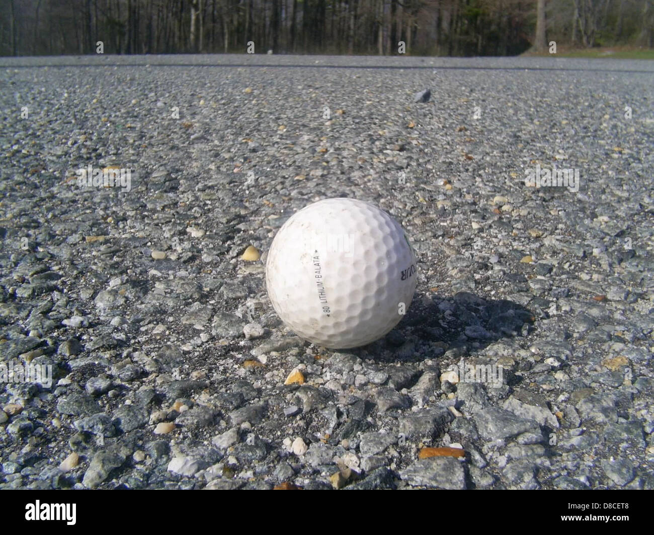 A golf ball resting on gravel Stock Photo - Alamy