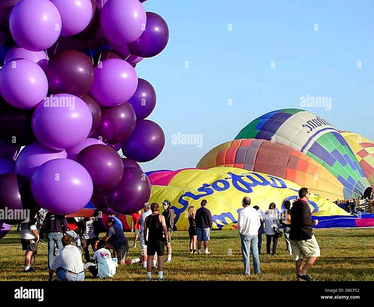 A colorful cluster of hot air balloons fills the sky, with each balloon ...