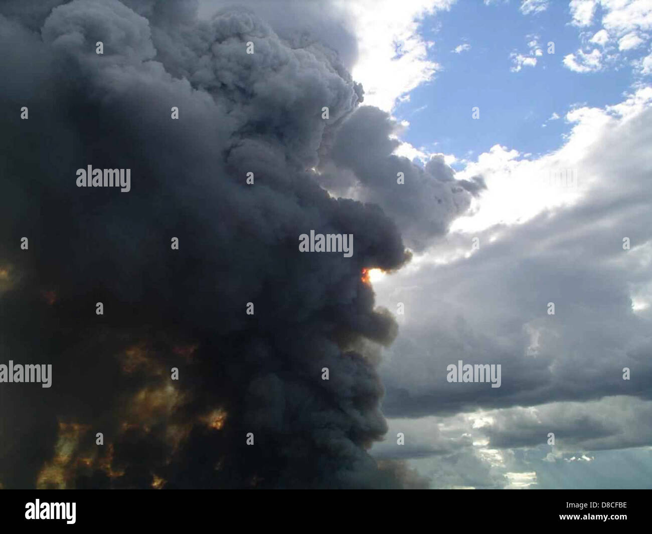 Thick black smoke rising from a fire, indicating a large and intense ...