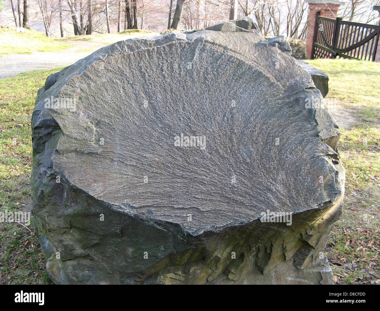 A large stone on the ground, showing its rough surface. The stone could ...