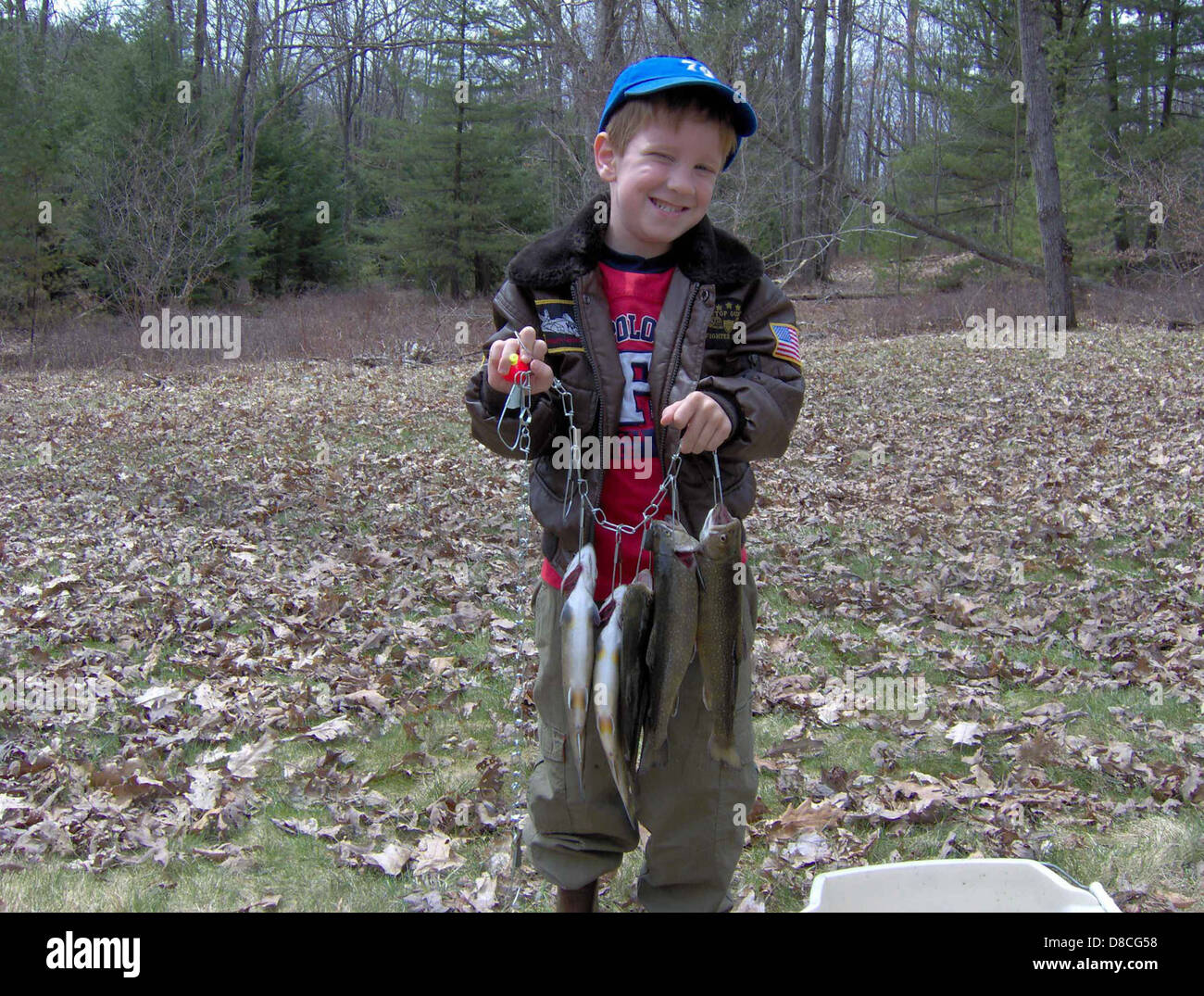 Boy fishing holding catched fish Stock Photo - Alamy