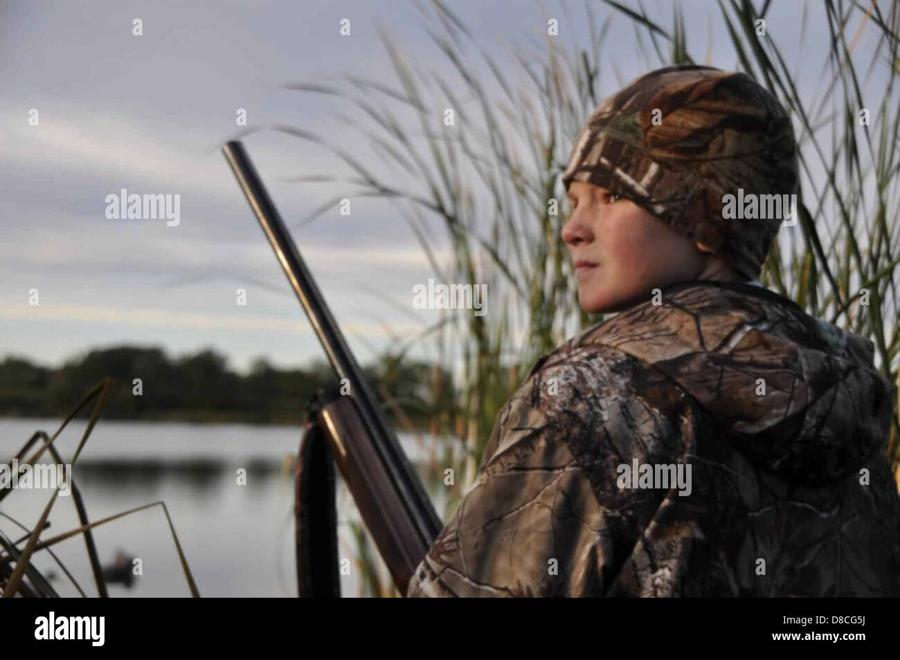 A young boy, dressed as a hunter, is observing the sky for incoming ...