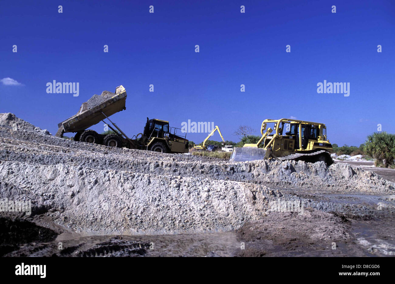 A bulldozer and truck working together on a construction site, with the ...