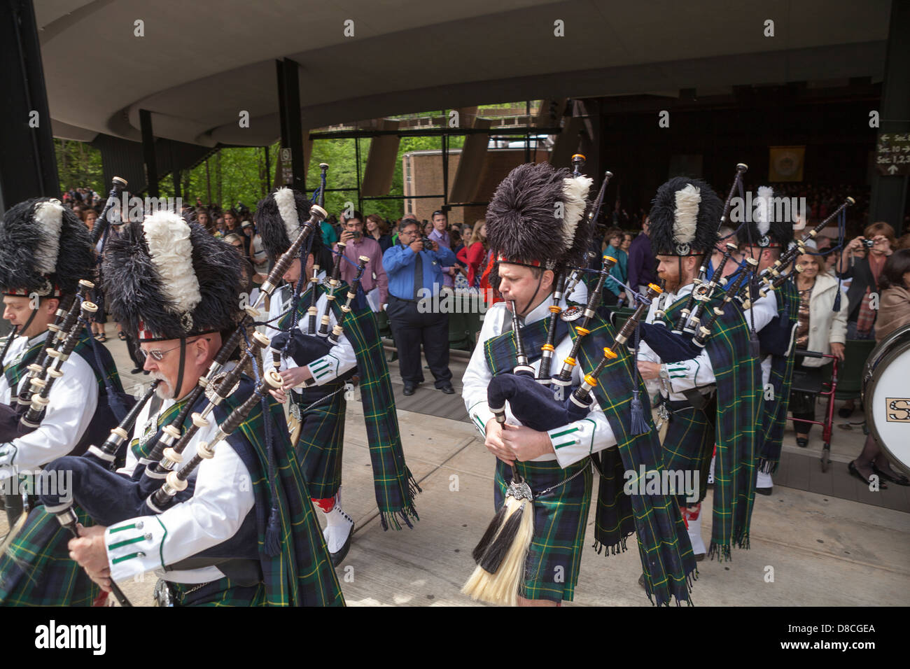 A marching band including bagpipes and drums celebrates a graduation at ...