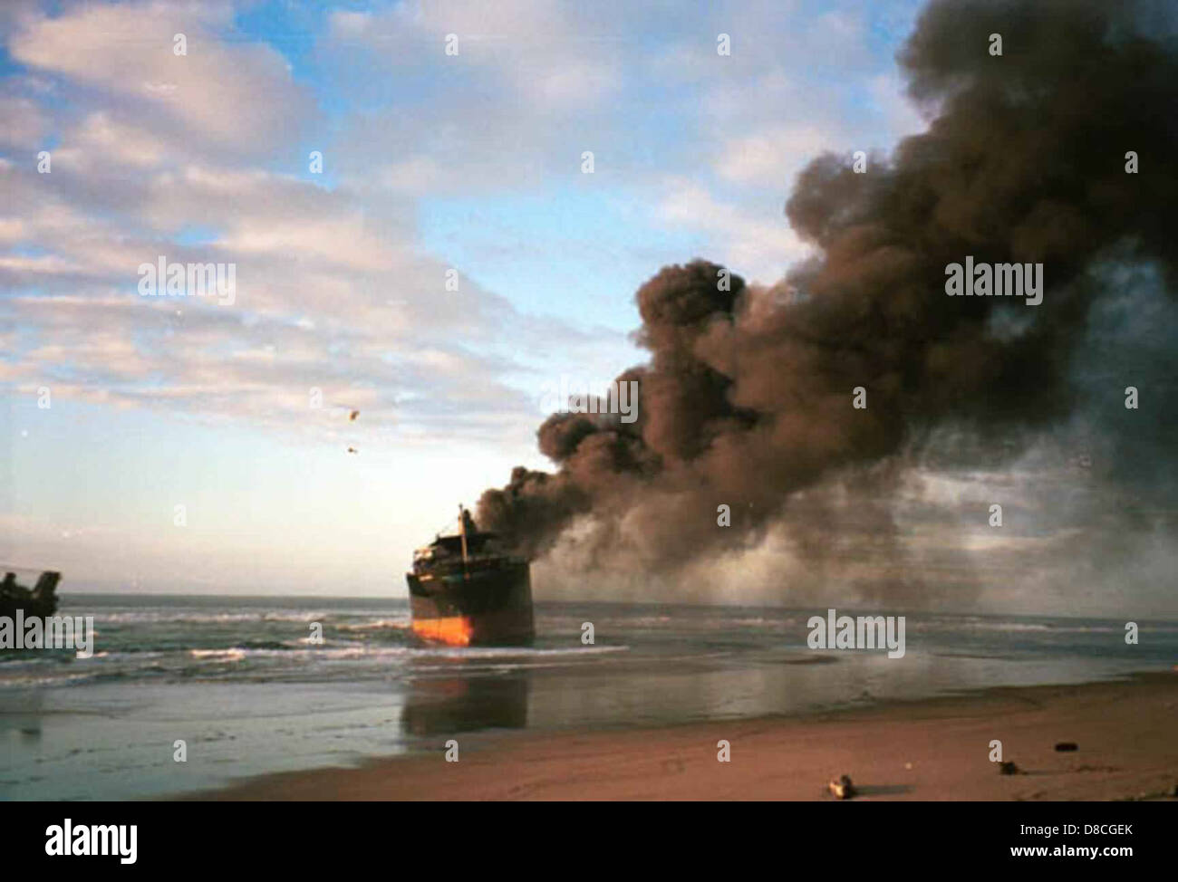 This image depicts a ship on fire, with thick smoke and flames emerging ...