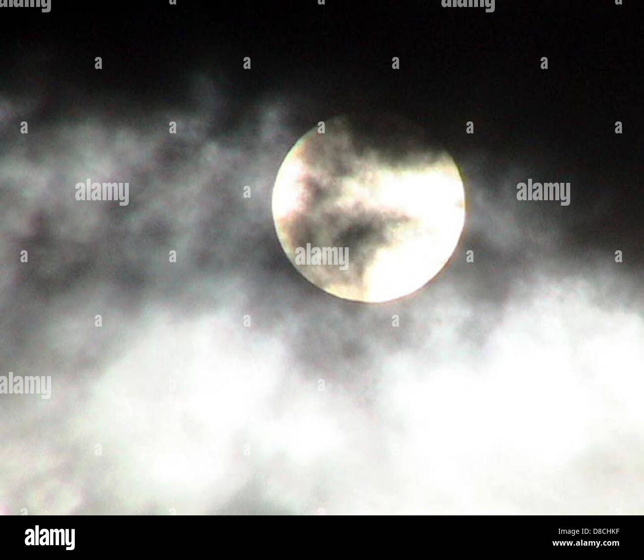 A scene showing the sun partially obscured by clouds, creating a ...