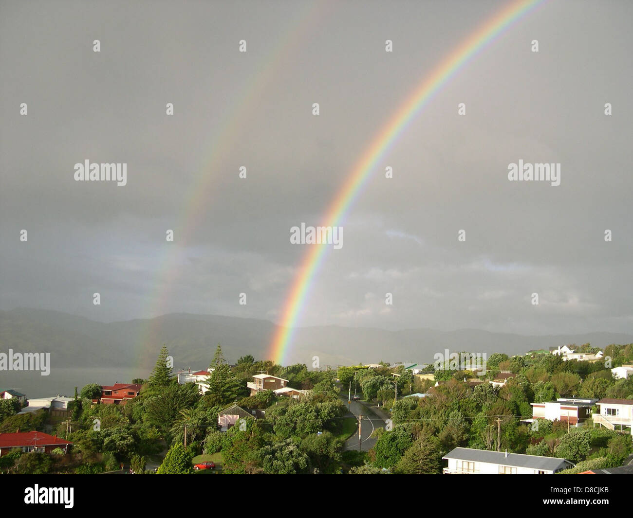 This image captures a stunning double rainbow, where two distinct arcs ...