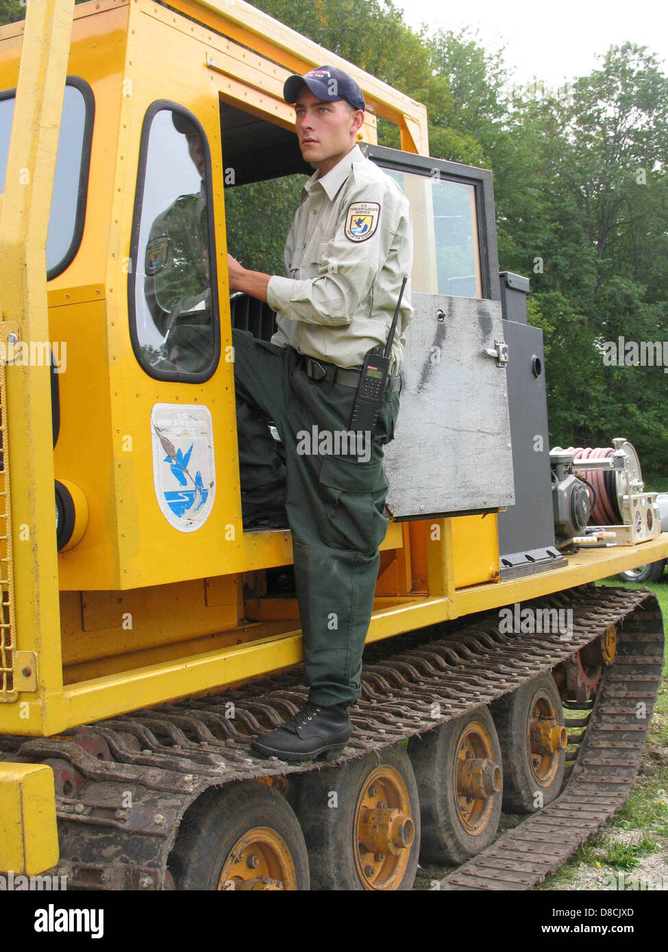 An employee standing on a heavy equipment vehicle, typically used in ...