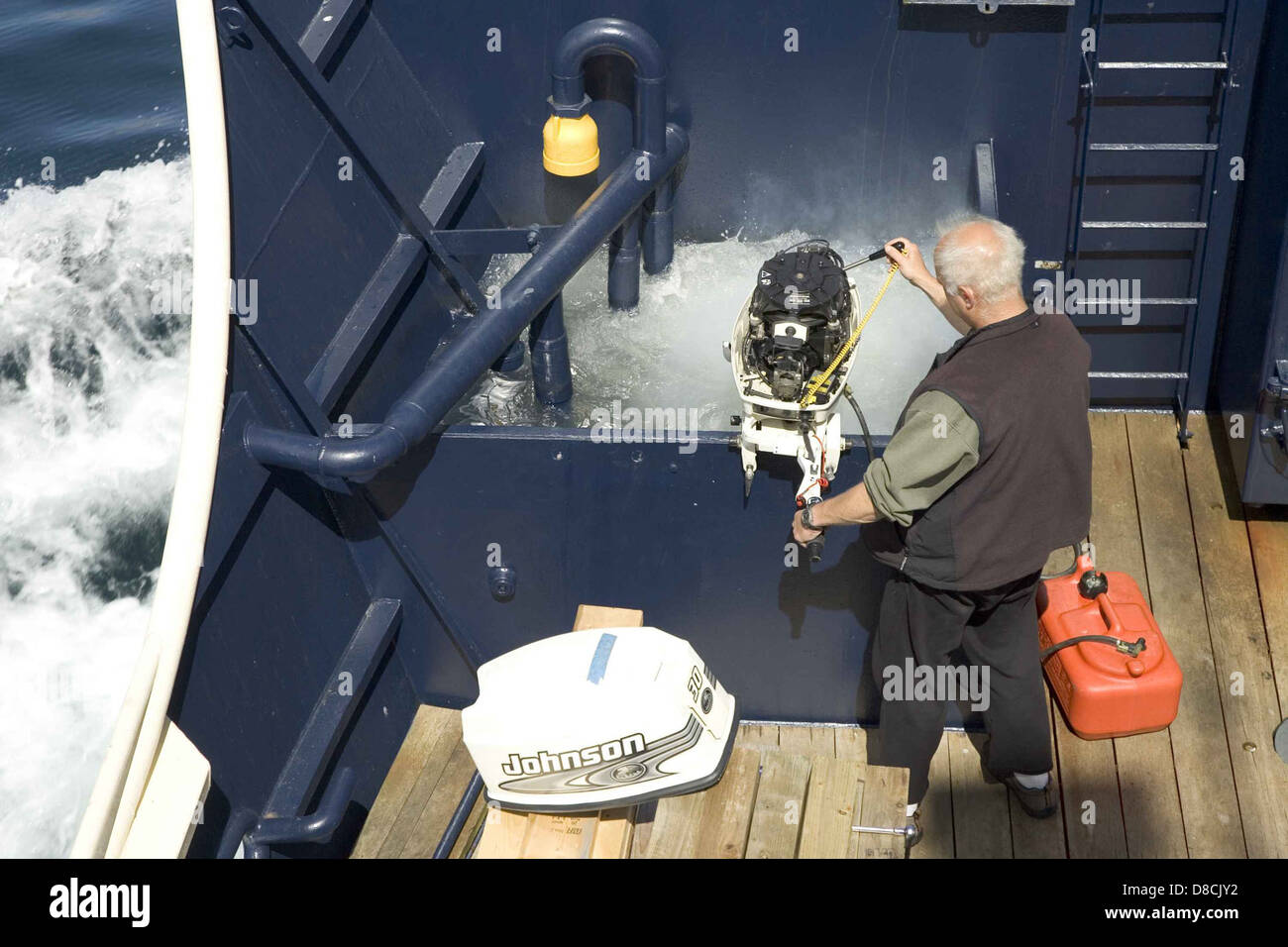 An engineer working on a skiff motor, inspecting and maintaining the ...