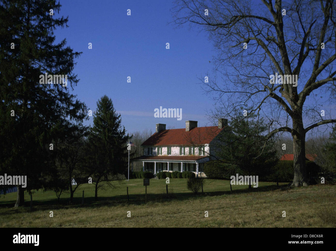 A rustic farmhouse sits on a large farm field, surrounded by open land ...