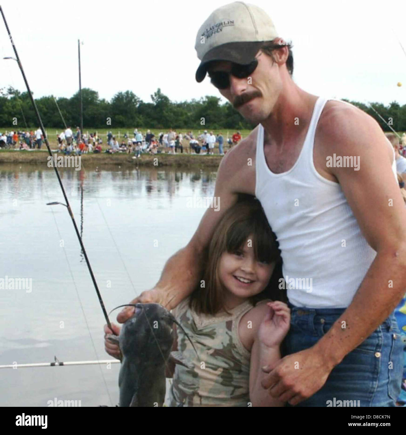 A father and daughter posing with a catfish they caught together. The ...