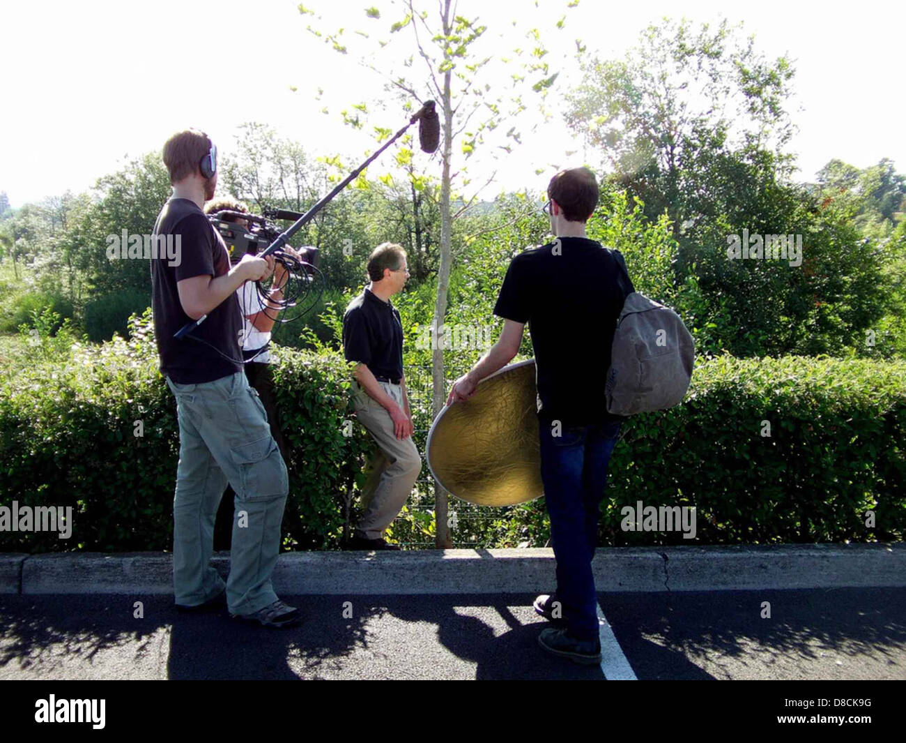 A film crew is shown filming a news segment with a cameraman ...
