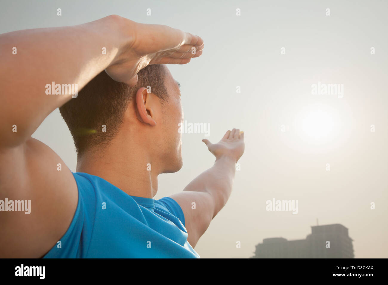 Young Muscular Man Stretching Toward the Sun Stock Photo - Alamy