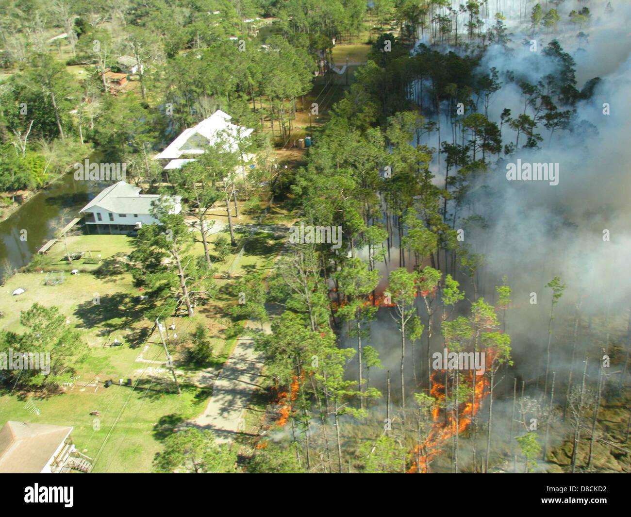 A fire spreads around homes in an urban area, with visible flames and ...