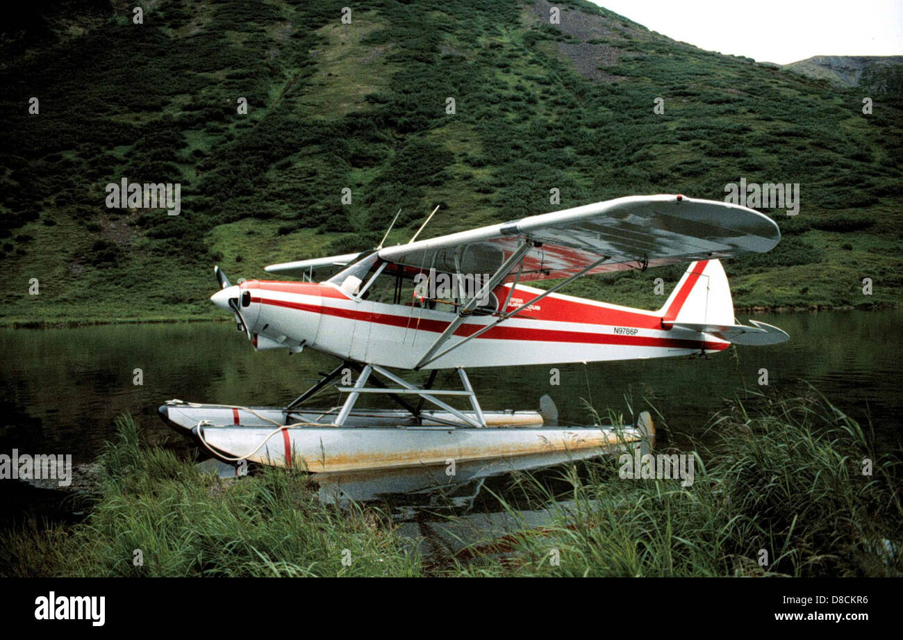 A floatplane aircraft resting on the calm surface of a body of water ...