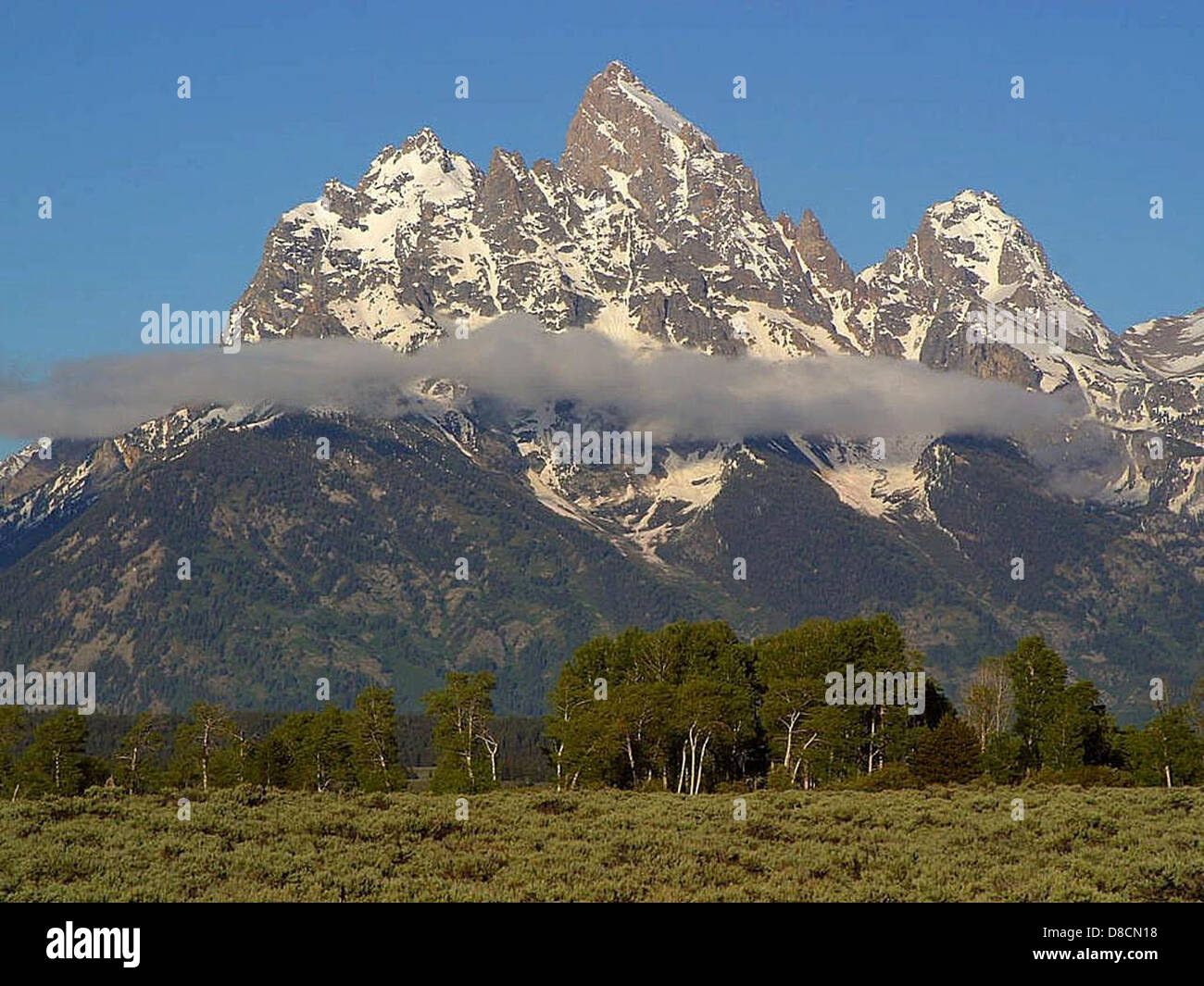 The Grand Tetons, towering over the surrounding valley, illuminated by ...