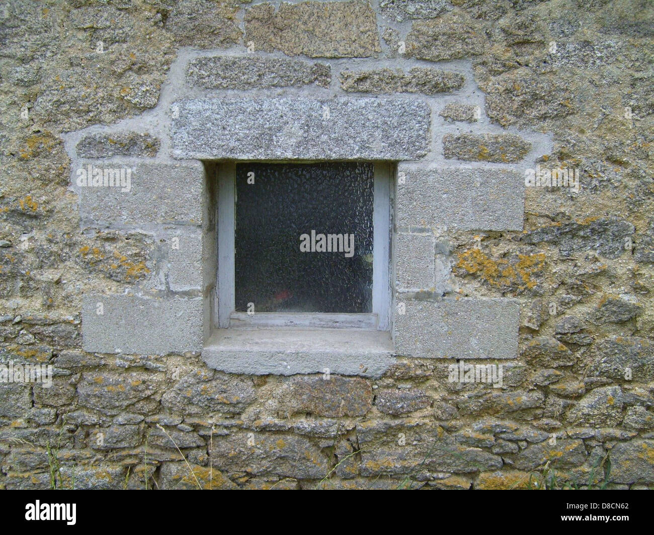 A granite wall with a window is shown, emphasizing the contrast between ...