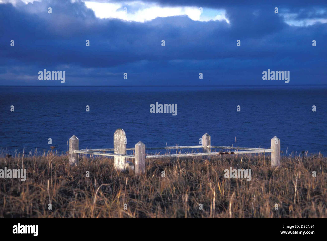 A cemetery located near a beach, with gravestones and memorials set ...