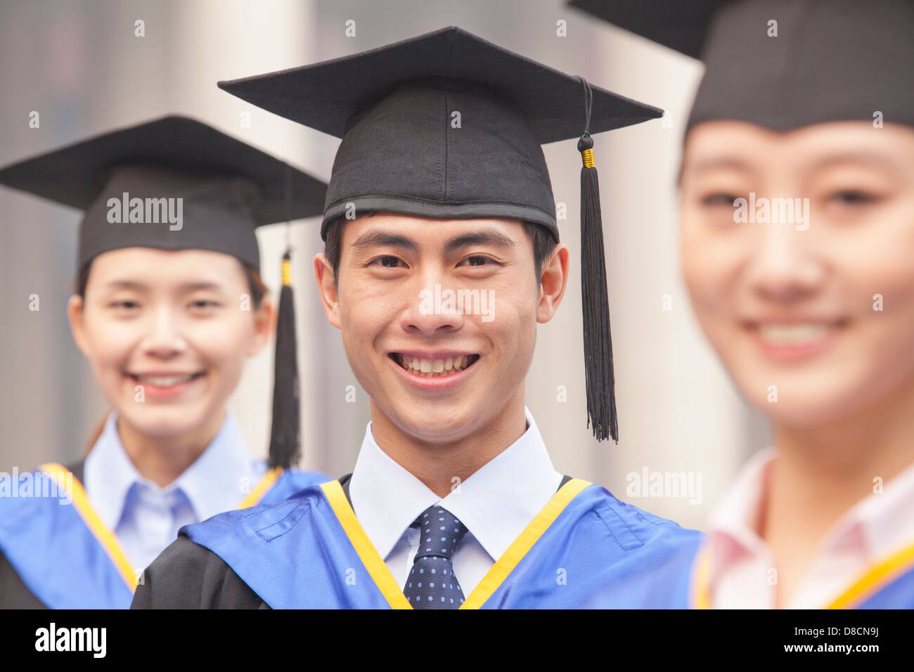 Three University Graduates Smiling in a Row Stock Photo - Alamy