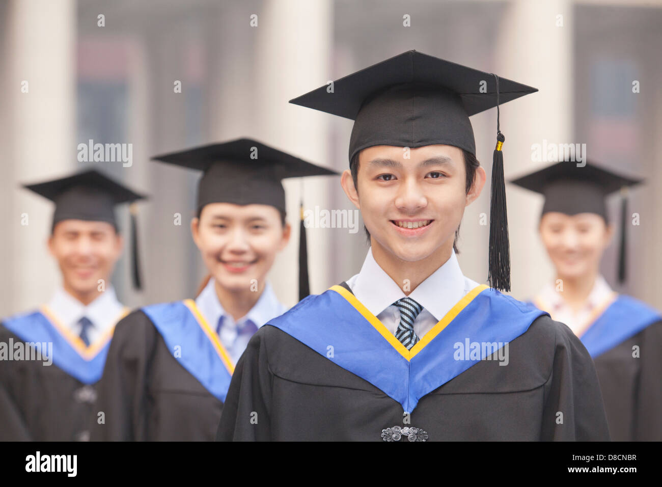 Four University Graduates Smiling, Looking at Camera Stock Photo - Alamy