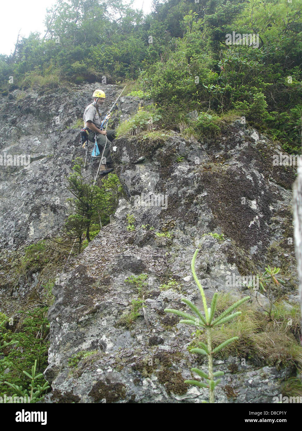 A hiker is seen navigating a rugged mountain trail, equipped with ...