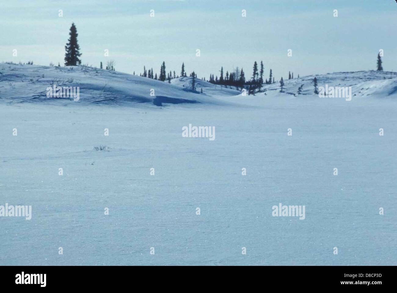 A winter scene showing hills covered in snow, with a clear sky and ...