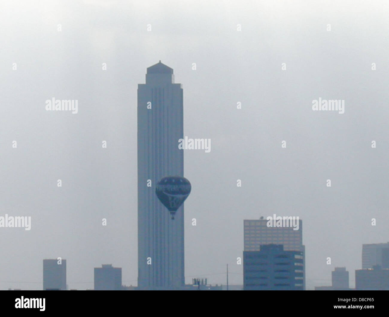 A hot air balloon floats gracefully by the Williams Energy Tower, a ...