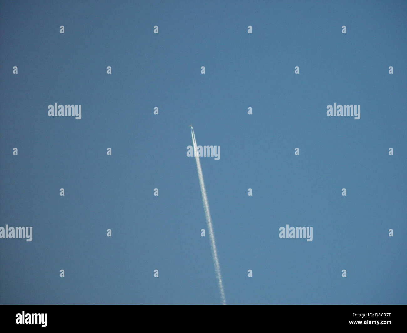 A jet aircraft is shown leaving a contrail as it flies through the sky. The contrail is a ...
