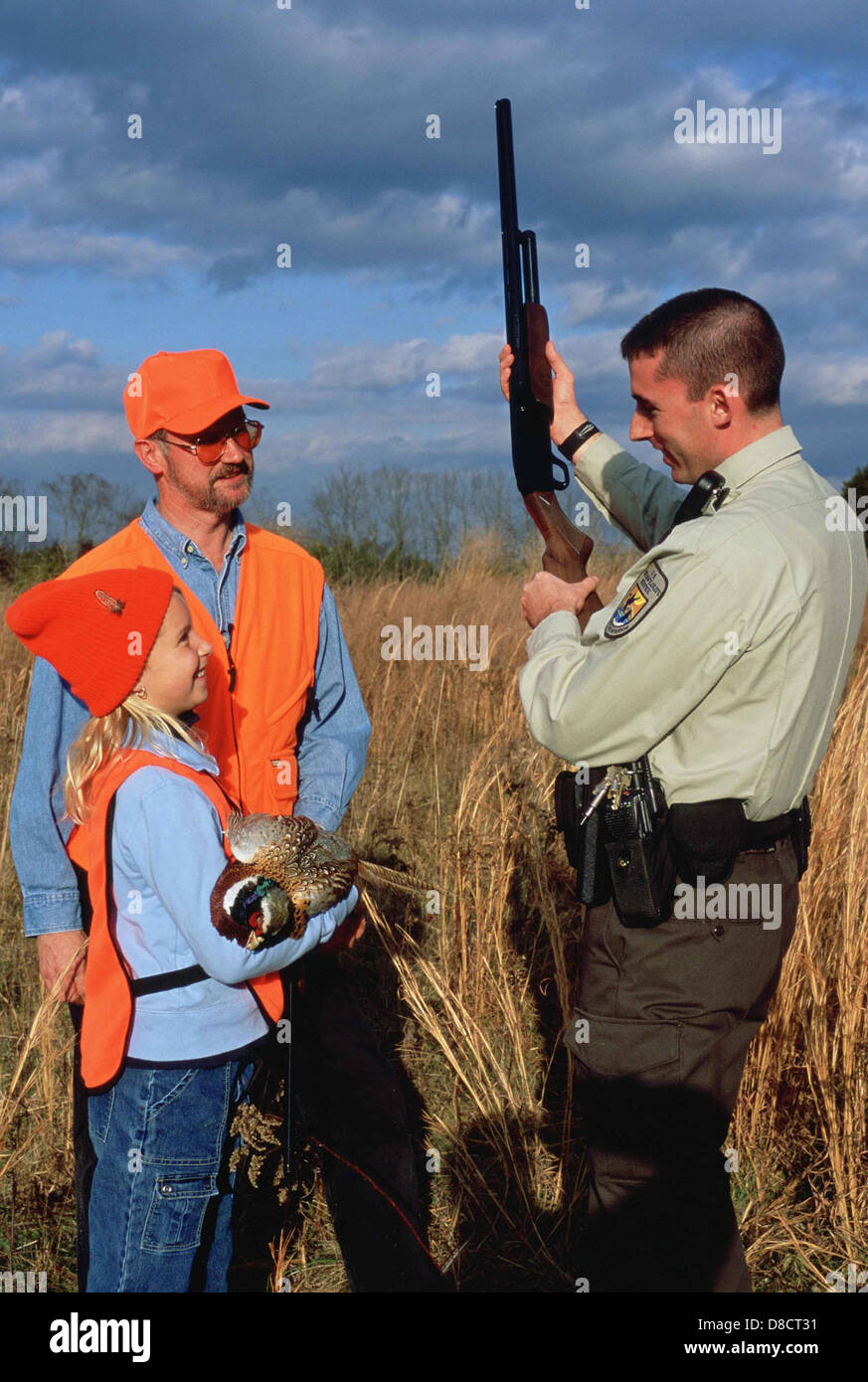 A law enforcement officer provides instruction on hunting safety to a ...