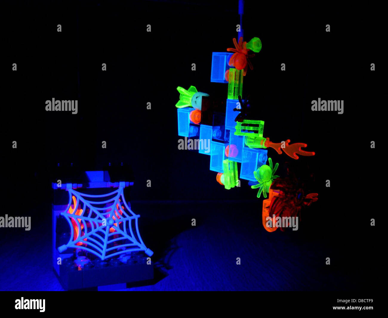 This image features a Lego cube illuminated under ultraviolet lighting ...